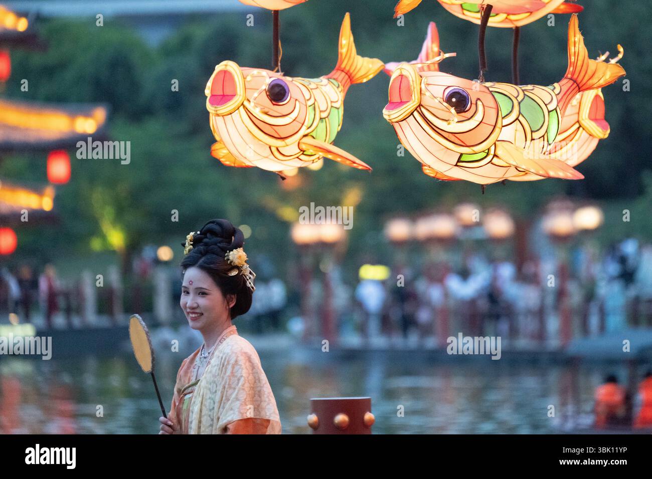 02 May 2025, China, Xi·an: A visitor stands under fish lanterns in the ...