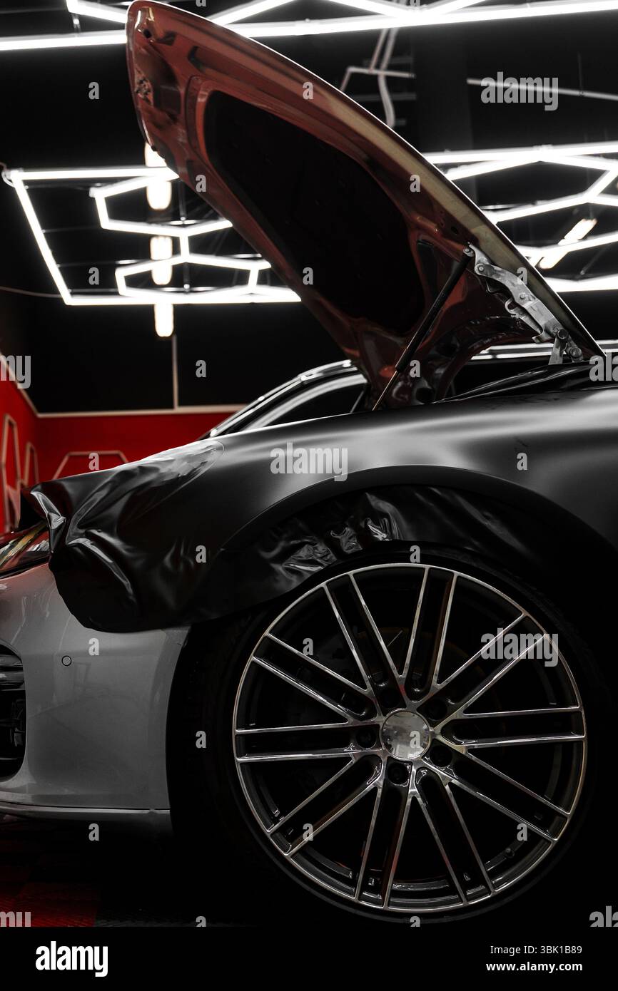 Matte black vinyl wrap application on front fender and wheel arch of ...