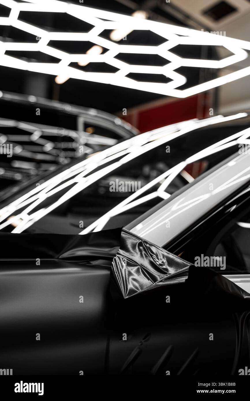 Car wrapping process using black matte vinyl stretched into place ...