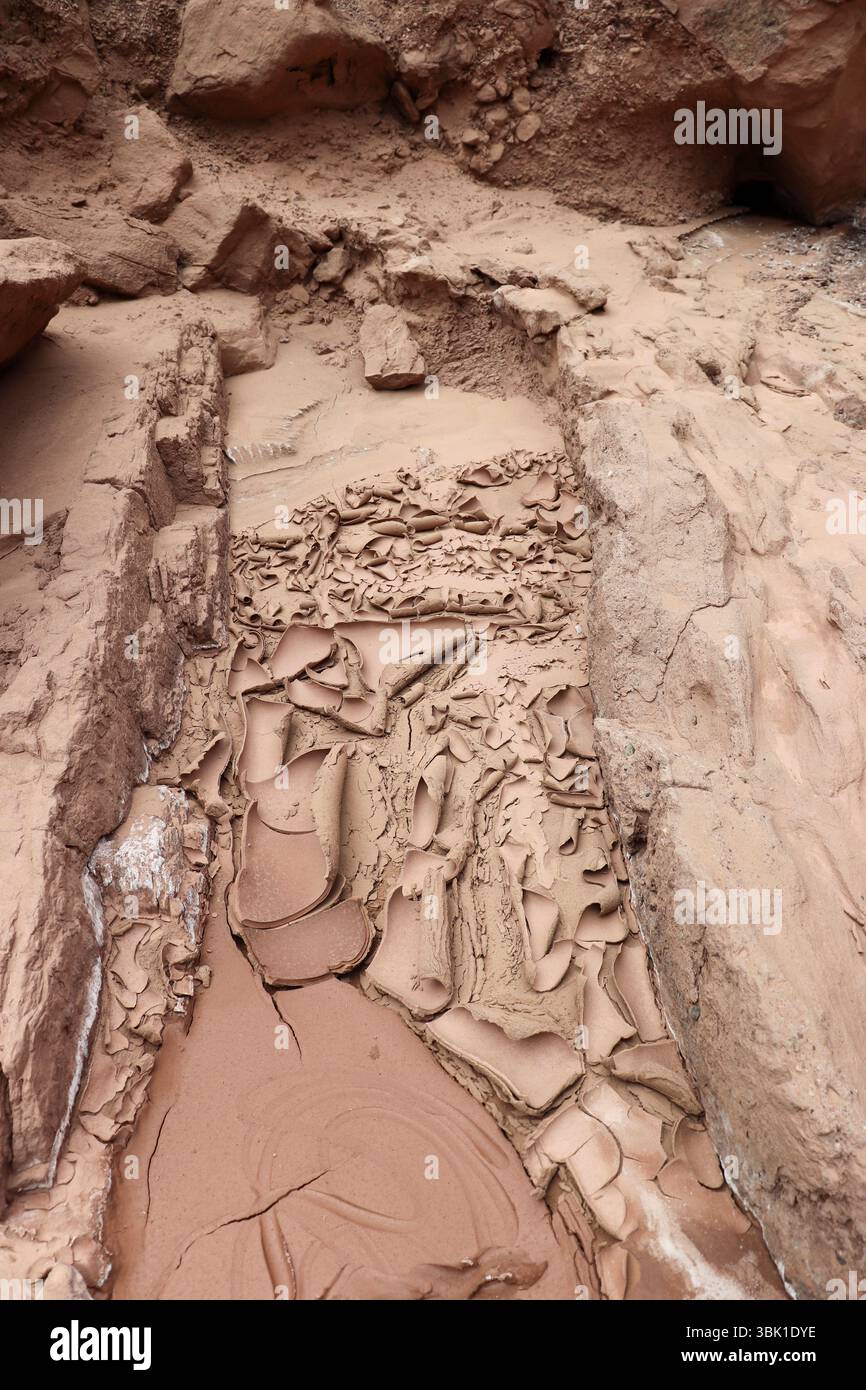 Detail of severely drought-cracked clay, confined between rocky walls ...