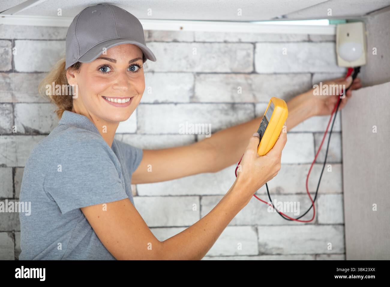 female electrician fixing electric unit Stock Photo - Alamy