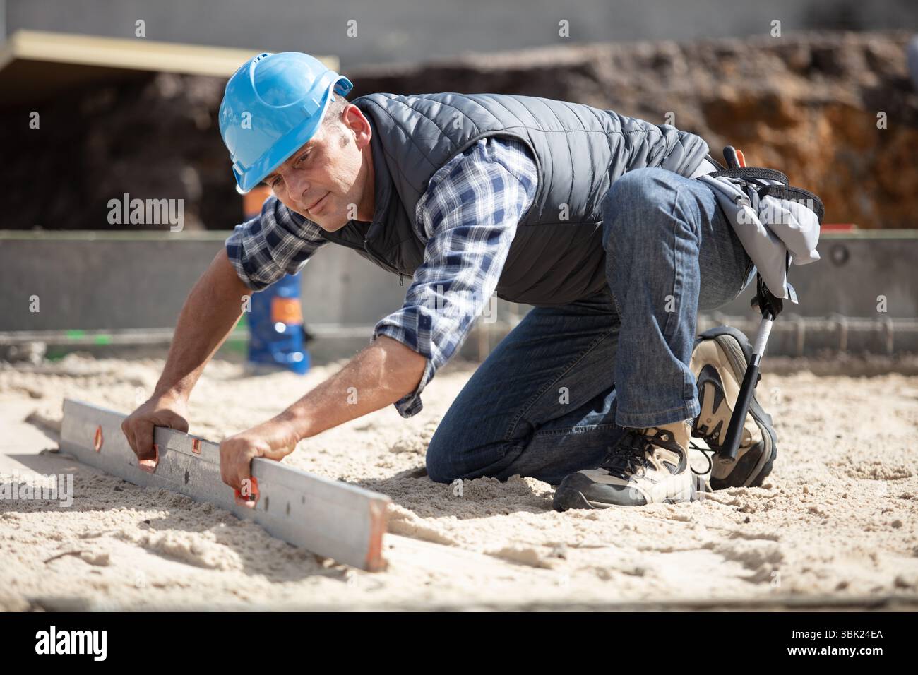 mason building using a wooden trowel and leveling Stock Photo - Alamy