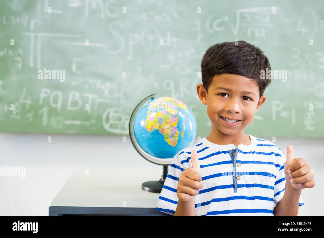 Asian child standing by chalkboard of math formulas, smiling with ...