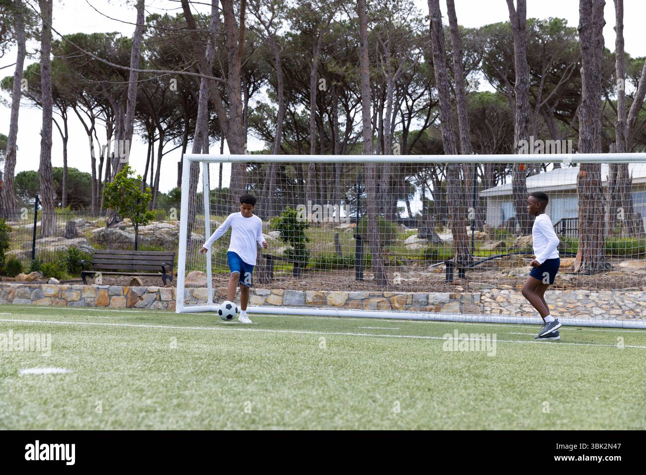 Diverse boys playing soccer on field, practicing teamwork and enjoying ...