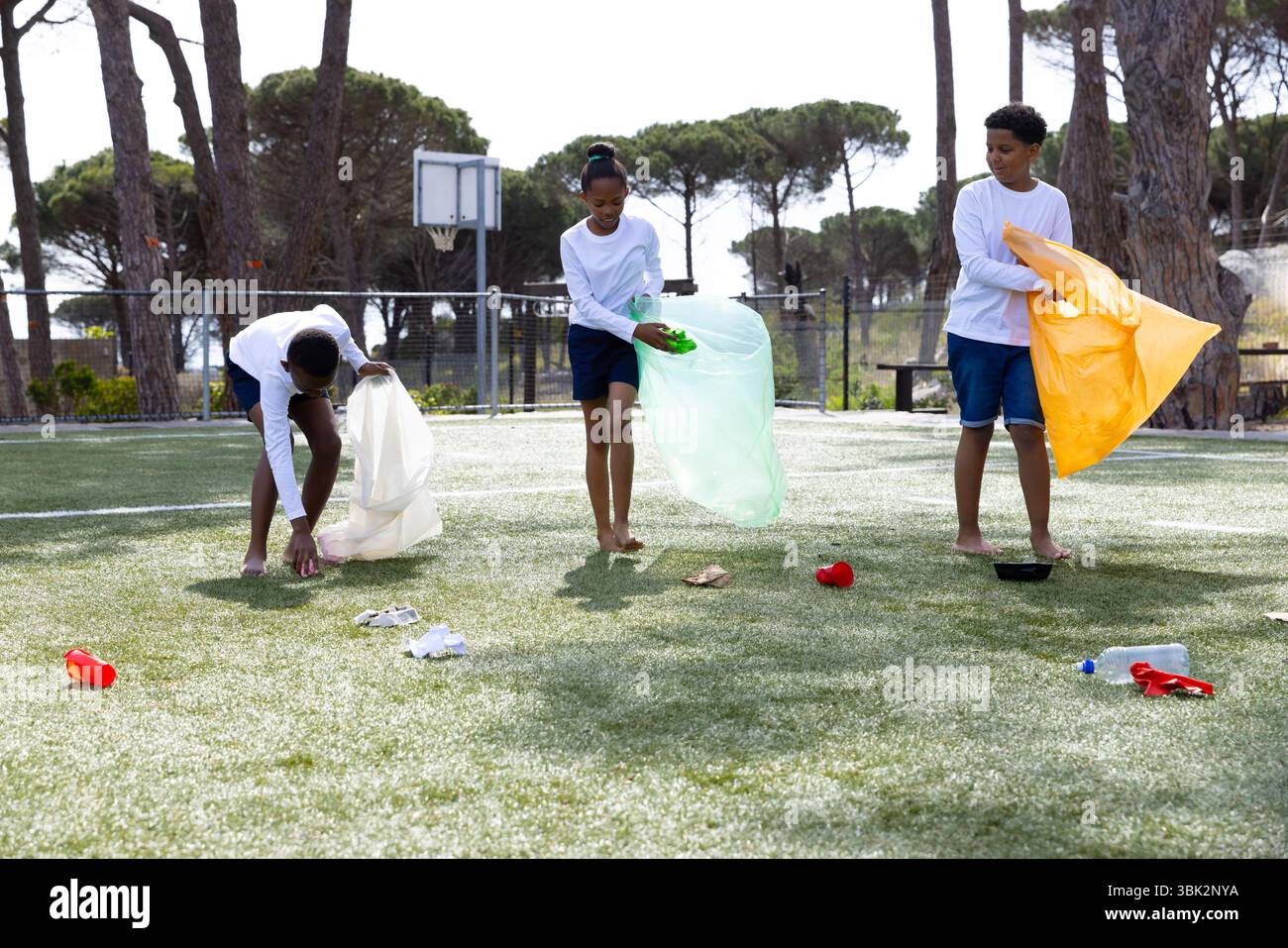 Diverse students cleaning up park, collecting litter in colorful bags ...
