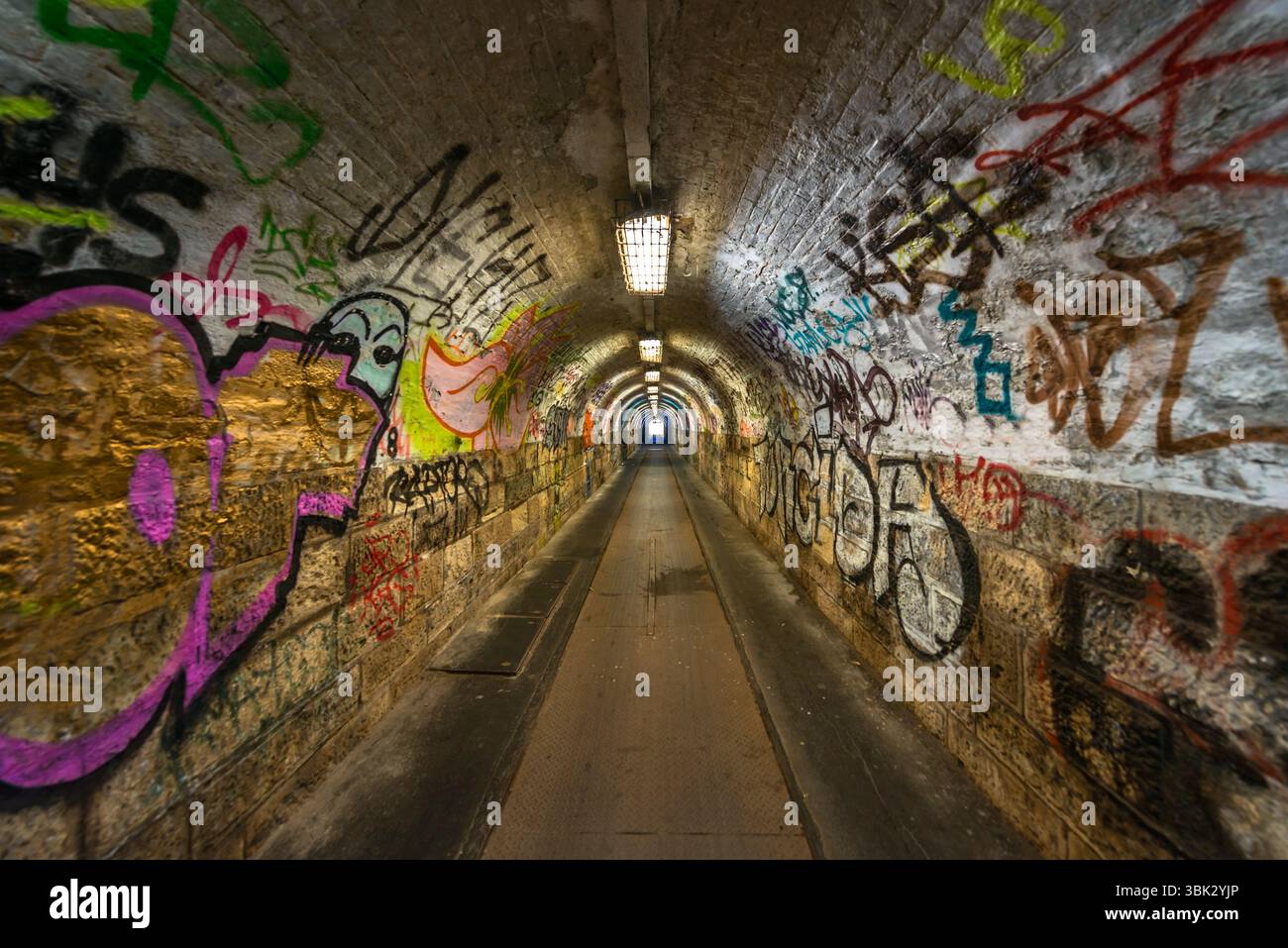 Dark and long undergorund passage with light Stock Photo - Alamy