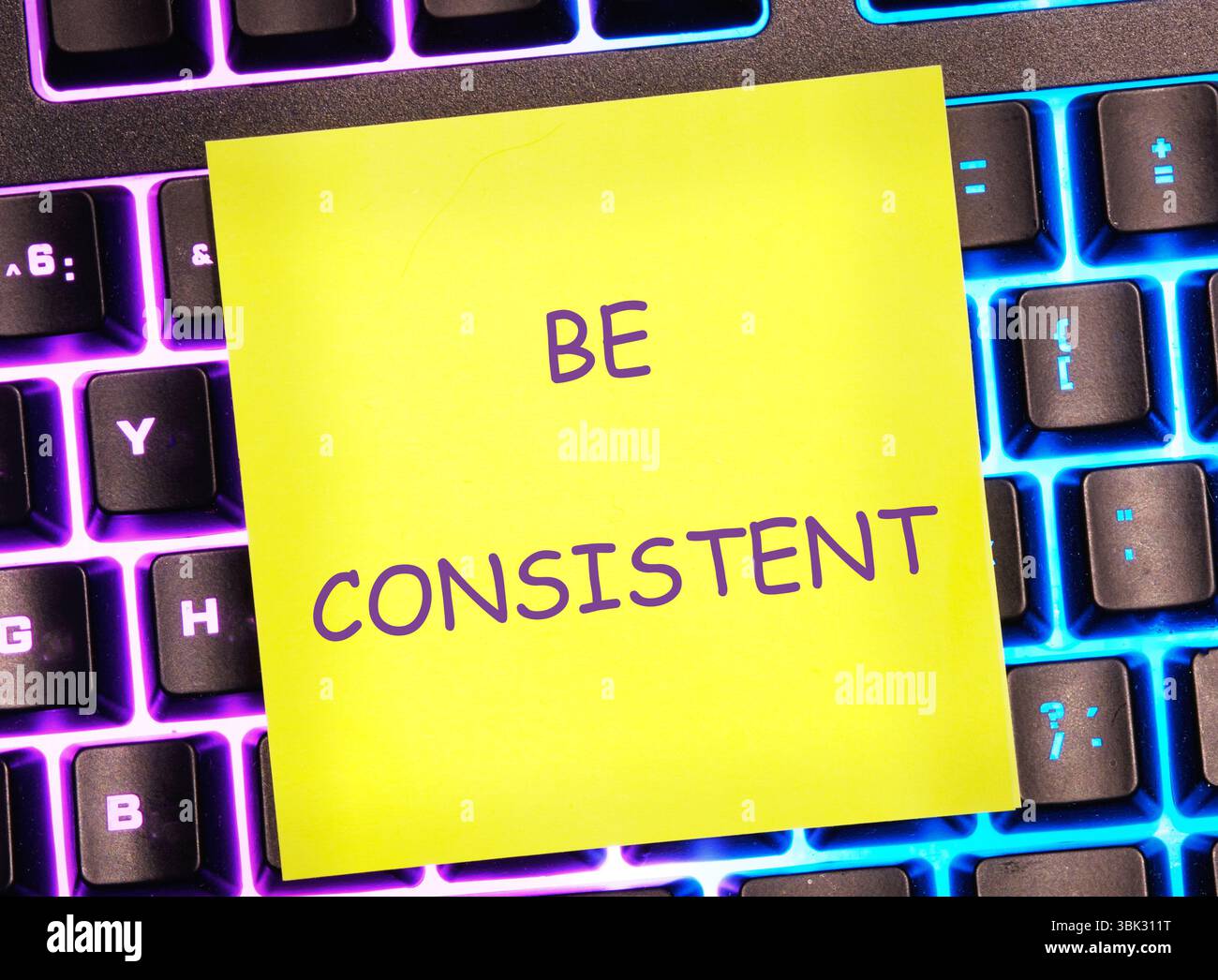 Business concept text BE CONSISTENT written on a bright yellow sticker ...