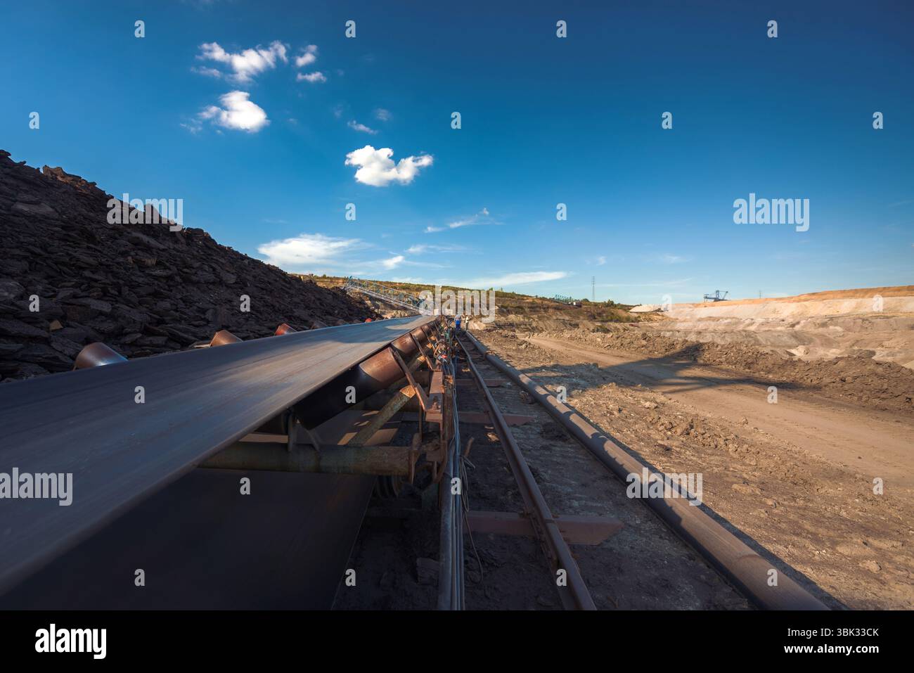 Long conveyor belt transporting ore to the power plant Stock Photo - Alamy