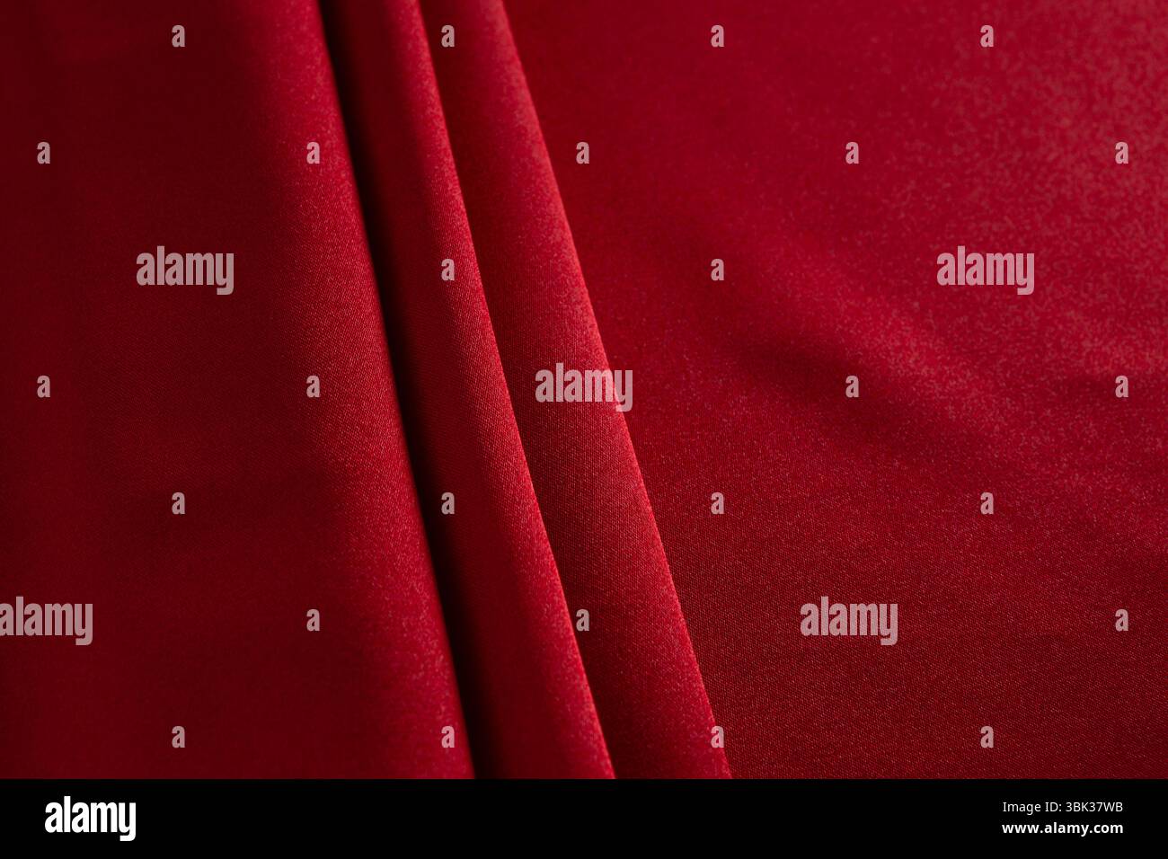 Deep red velvet fabric is draping in 3D render with smooth folds under ...