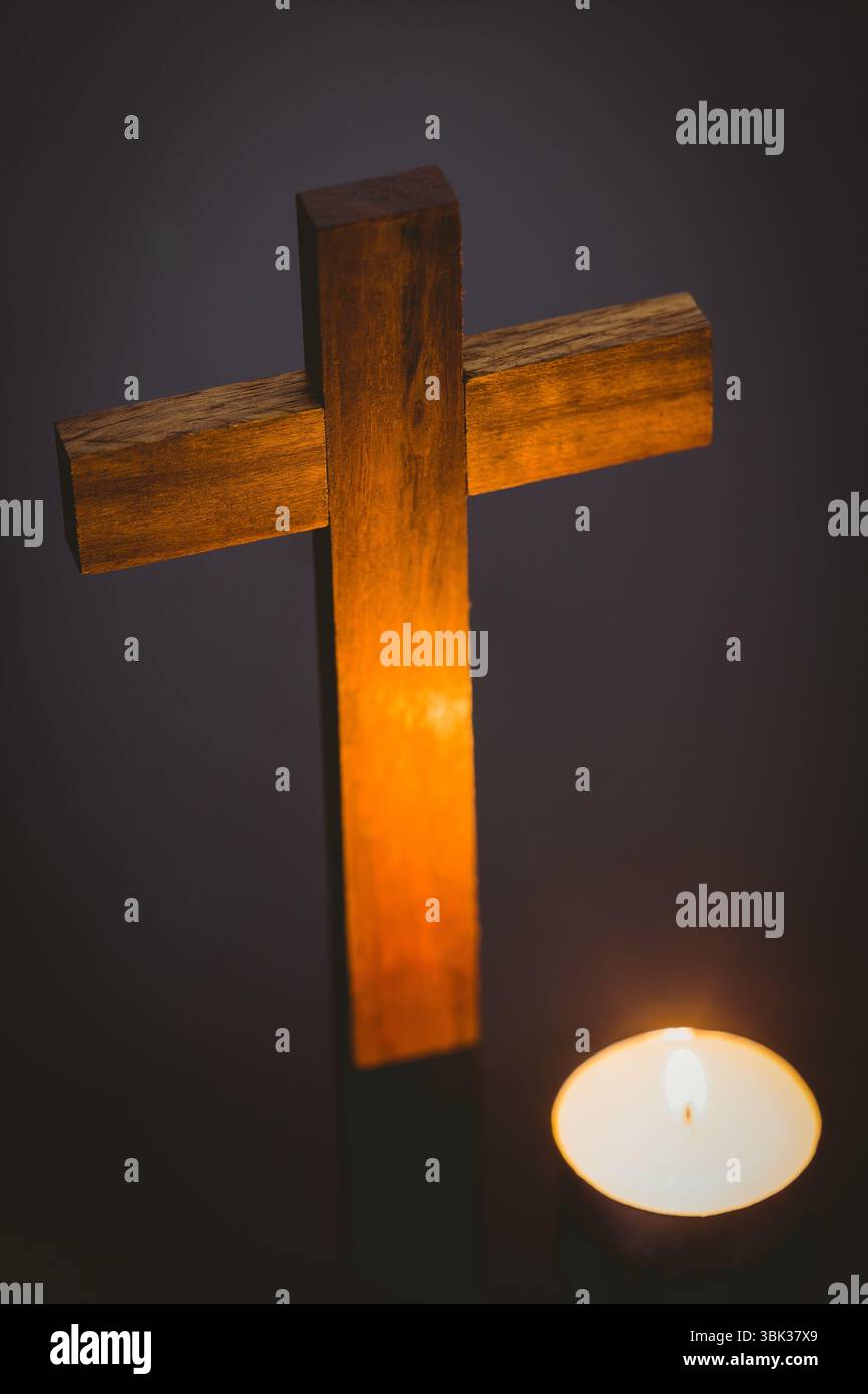 Lit candle by wooden cross Stock Photo - Alamy