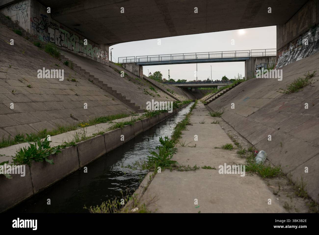 Sewage canal outdoors with dirty water flowing Stock Photo - Alamy