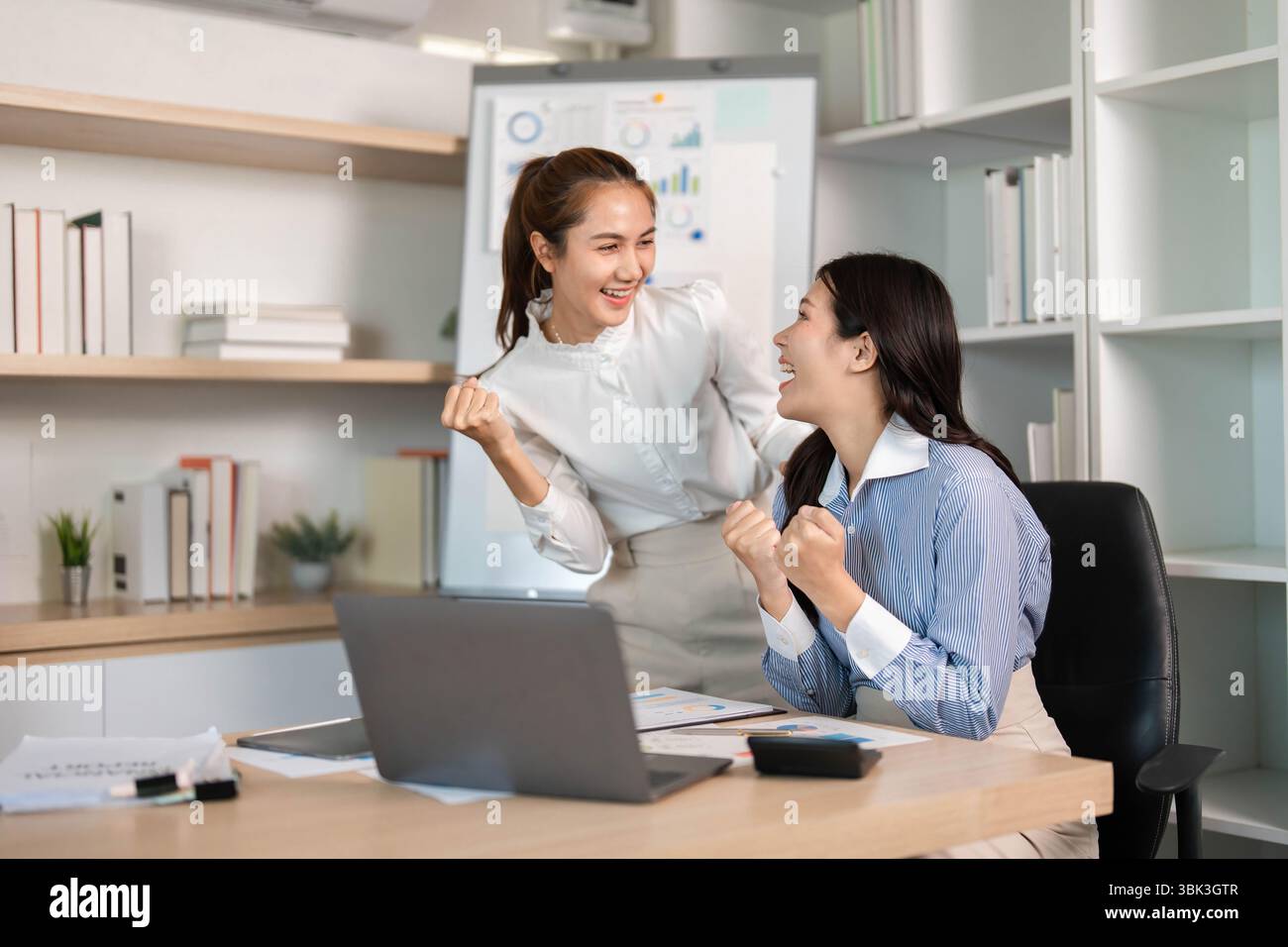 Team Celebration and Collaboration. Two young women celebrating a ...