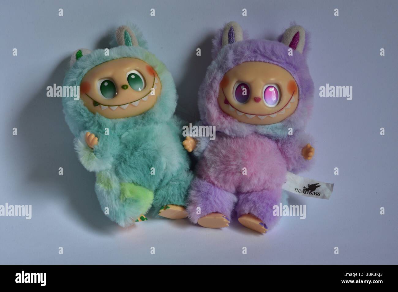 Two playful Labubu toy figures in a fluffy green and pink monster ...