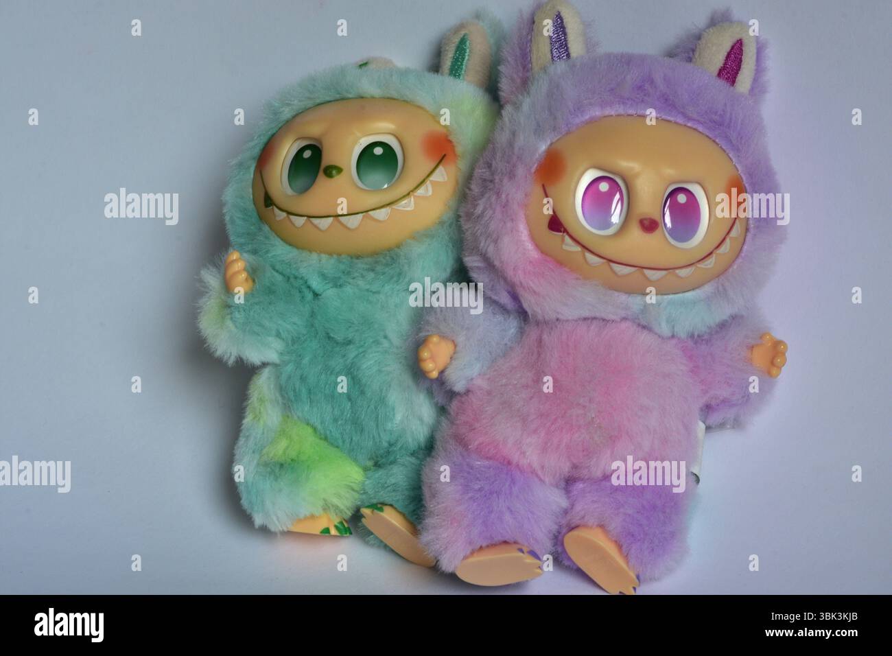 Two playful Labubu toy figures in a fluffy green and pink monster ...