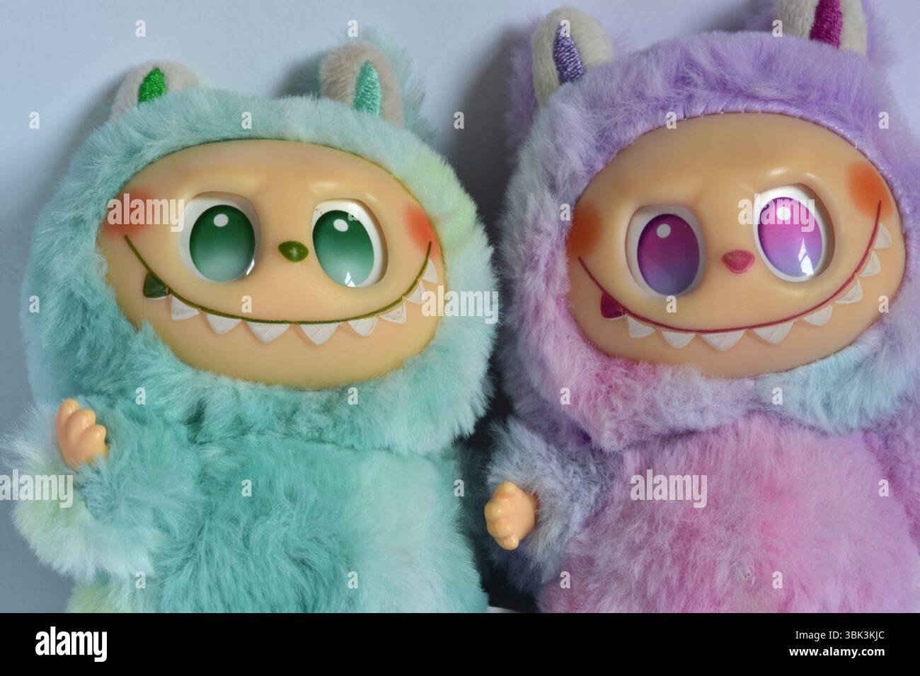 Two playful Labubu toy figures in a fluffy green and pink monster ...