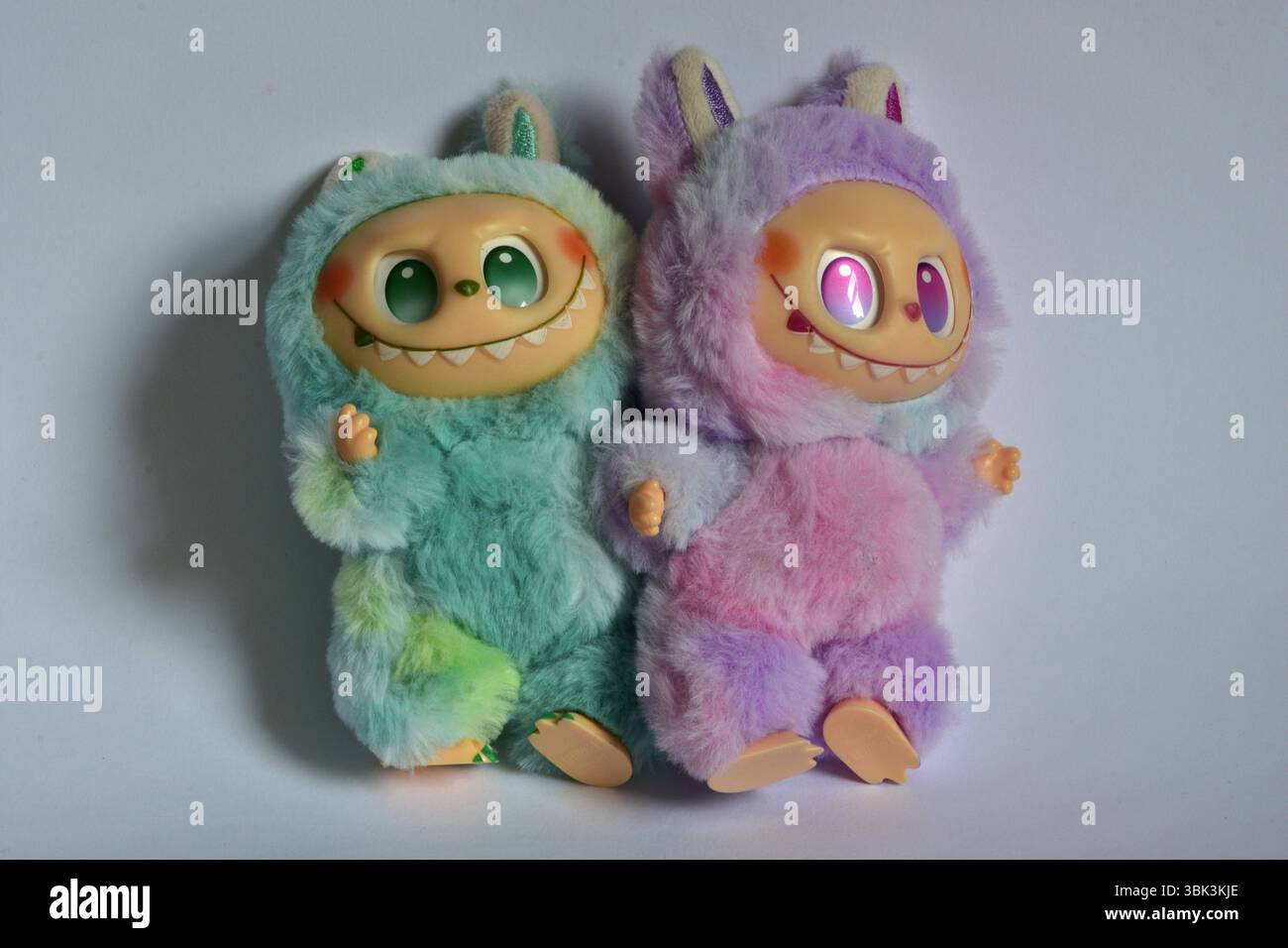 Two playful Labubu toy figures in a fluffy green and pink monster ...
