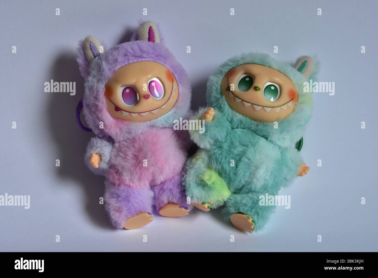 Two playful Labubu toy figures in a fluffy green and pink monster ...