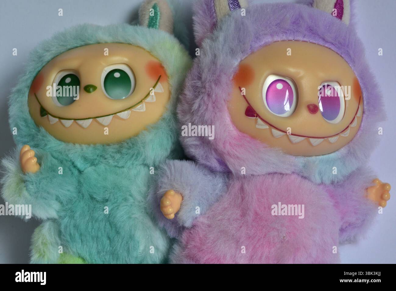 Two playful Labubu toy figures in a fluffy green and pink monster ...
