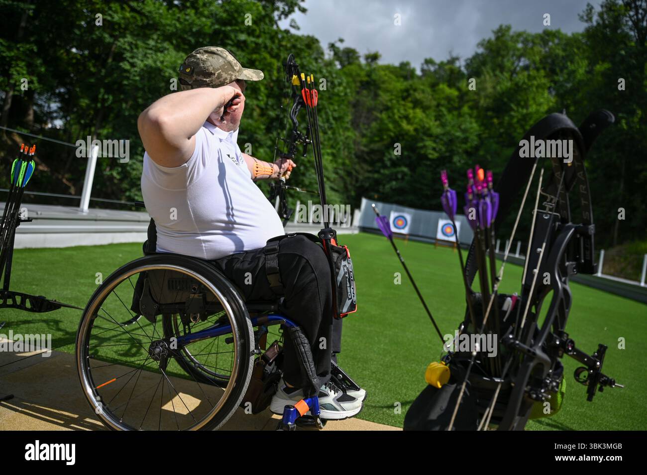 A veteran in a wheelchair aims a bow at the Strilnytsia municipal ...