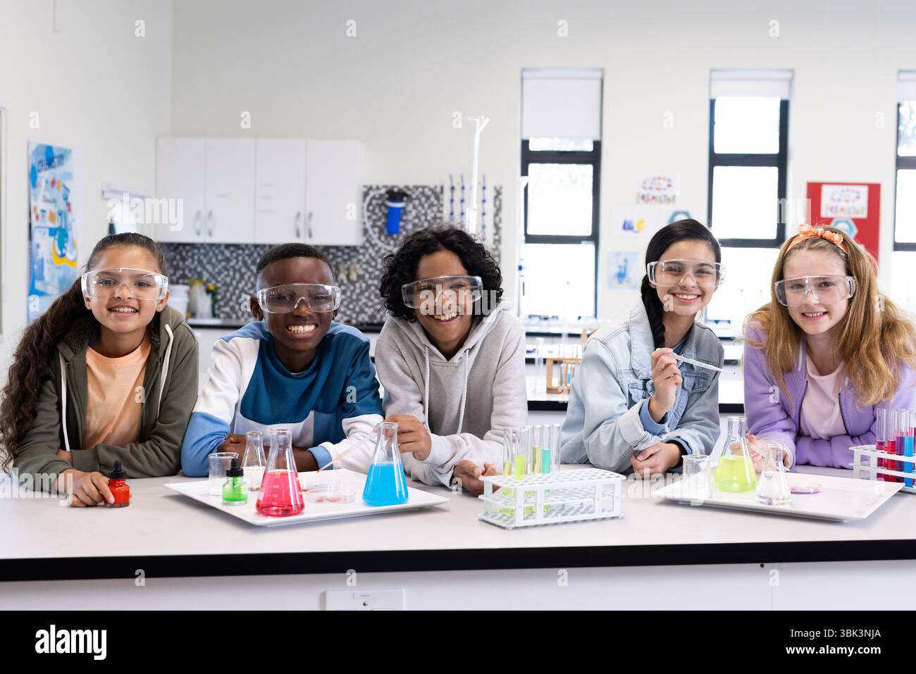 In school, diverse students conducting science experiment with colorful ...