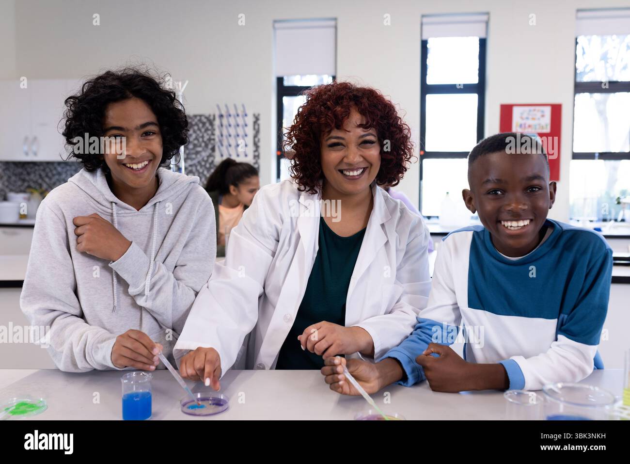 Science female teacher and diverse students experimenting with colorful ...