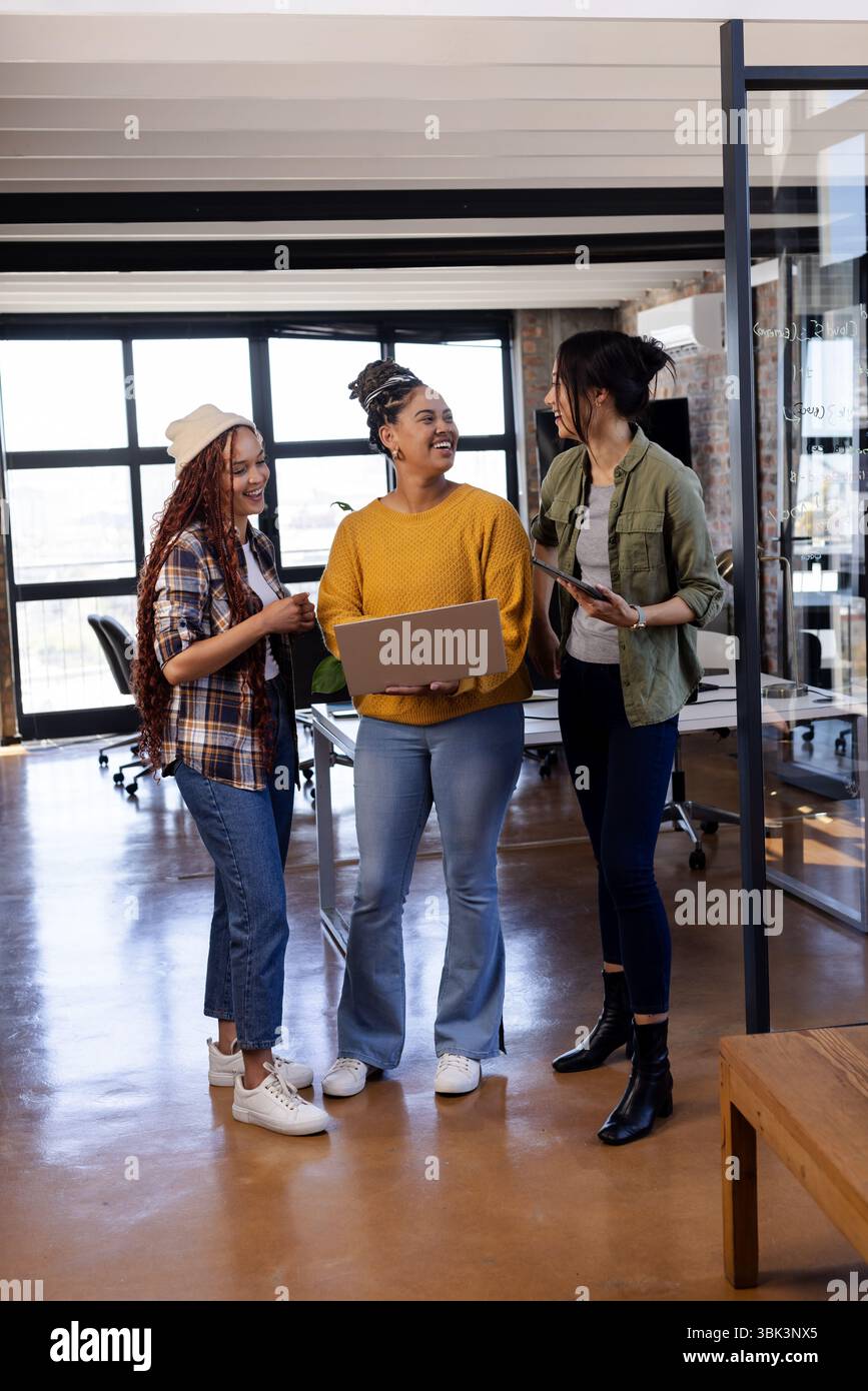 Diverse women in office collaborating on coding project with laptops ...
