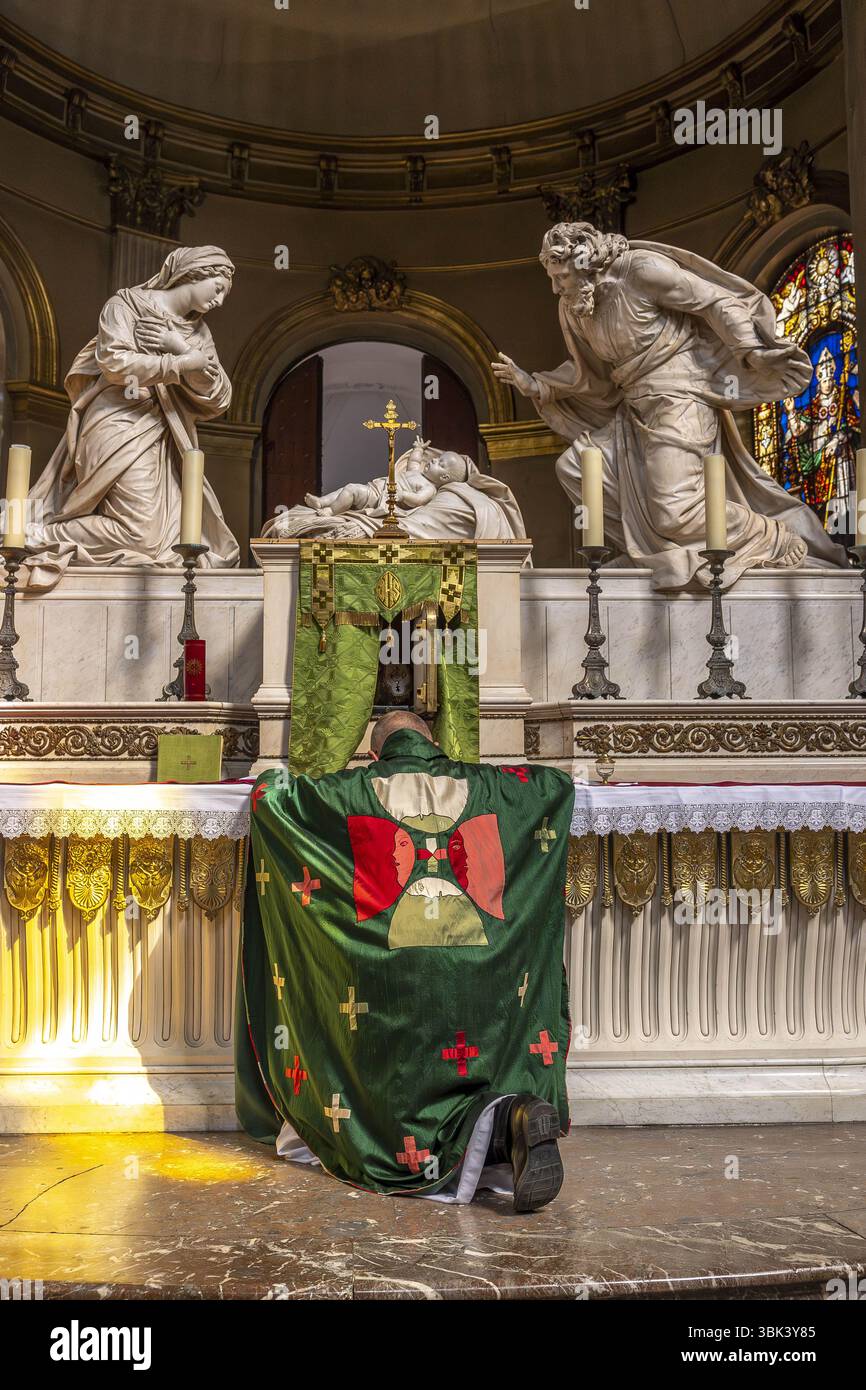 Mass in Saint Roch church, Paris, France. Priest kneeling in front of ...