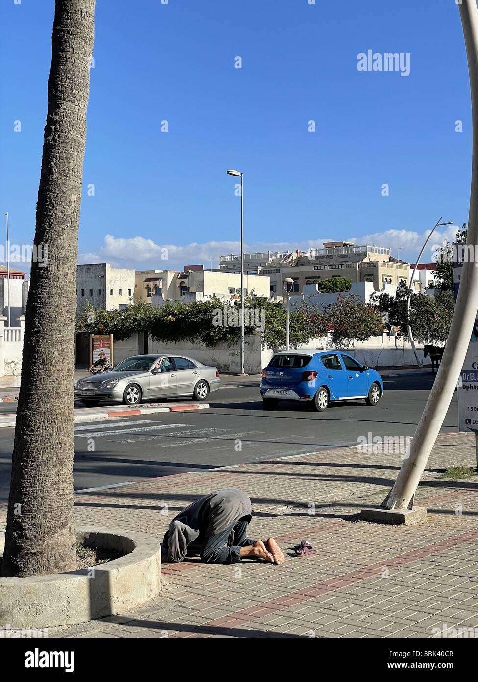Man praying on a sidewalk in Essaouira, Morocco Stock Photo - Alamy