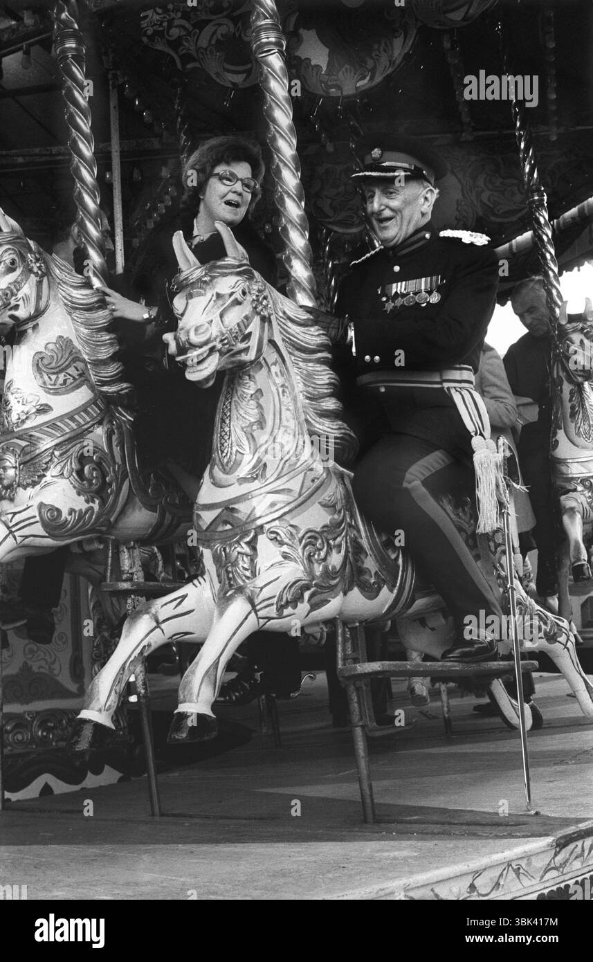 Funfair ride UK. Horse merry-go-round. Town hall dignitaries ride free ...