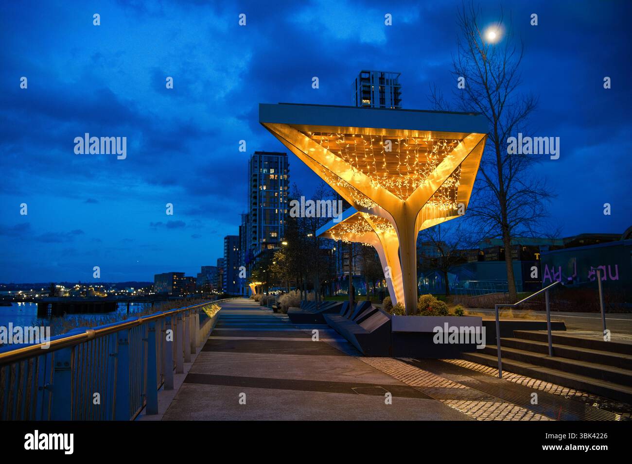 Modern riverside promenade with illuminated installation Stock Photo ...