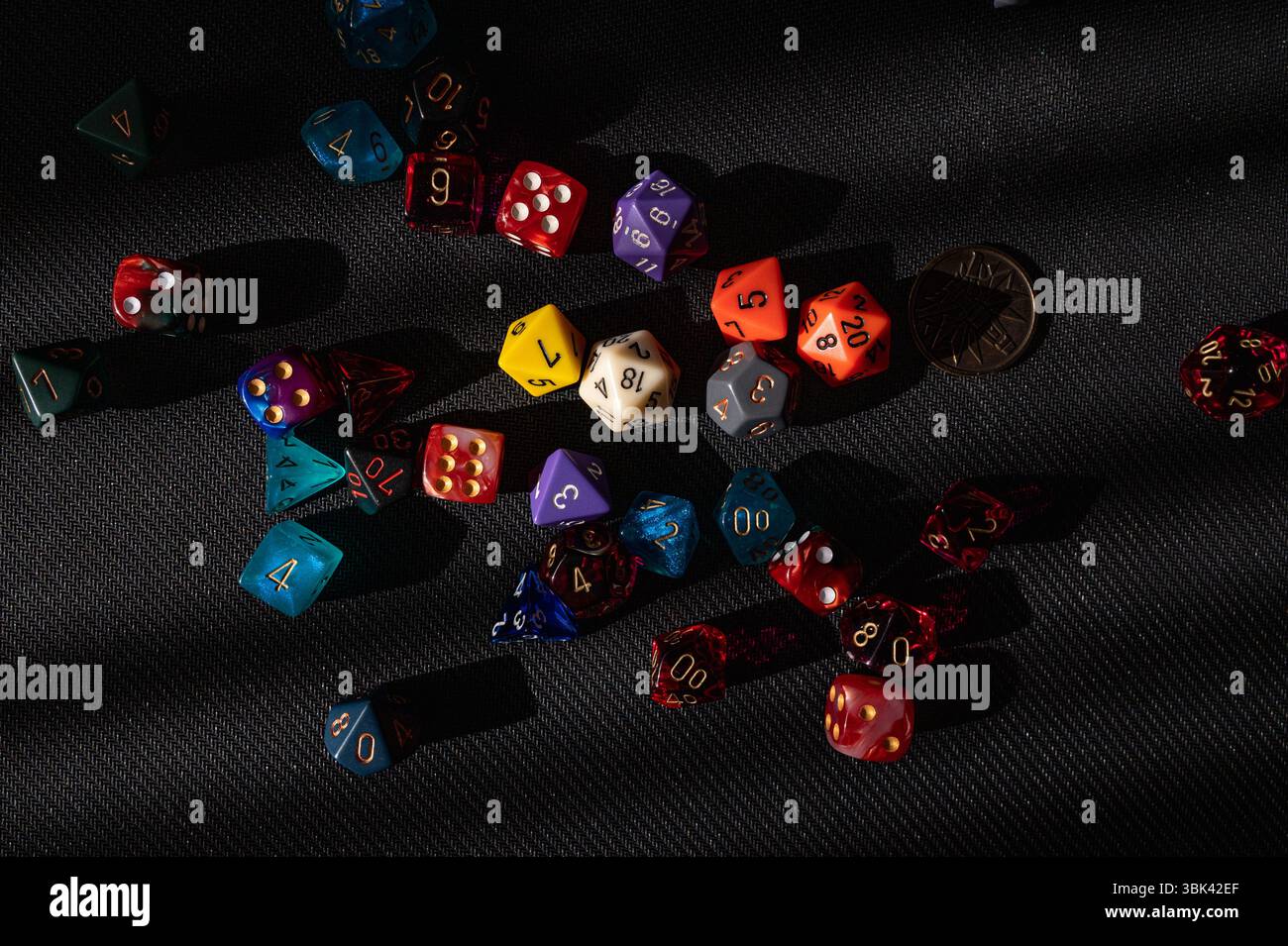 A top-down view of a colorful collection of polyhedral dice scattered ...