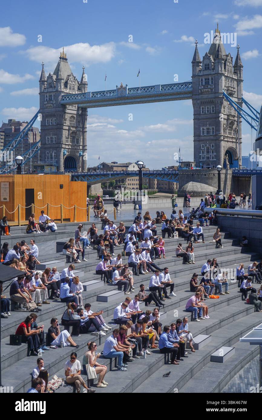 London, UK. 18 June 2025. City workers relaxing in the sunshine during ...