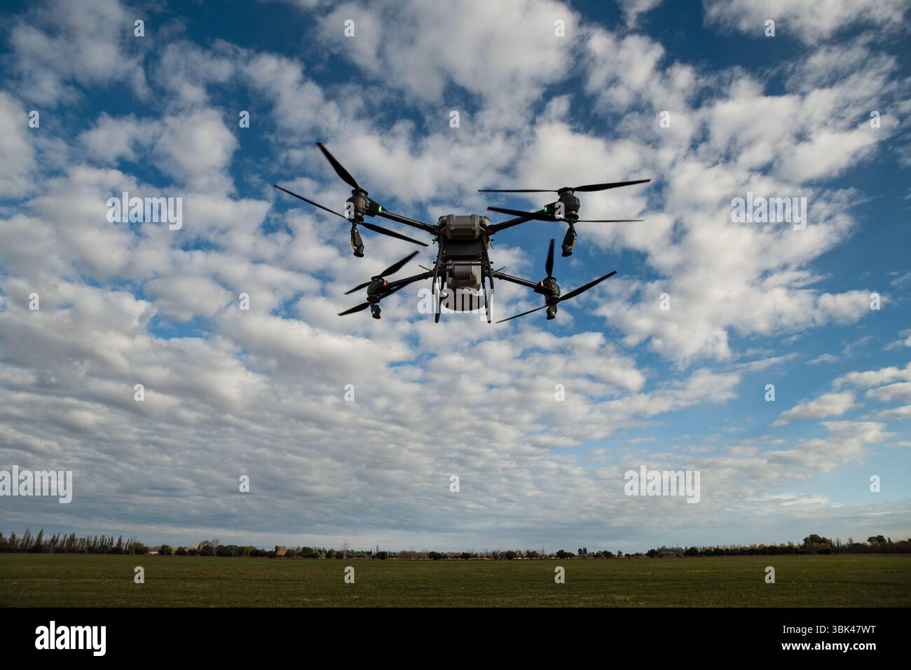 Agricultural drone spreading fertilizer on a newly planted field in ...