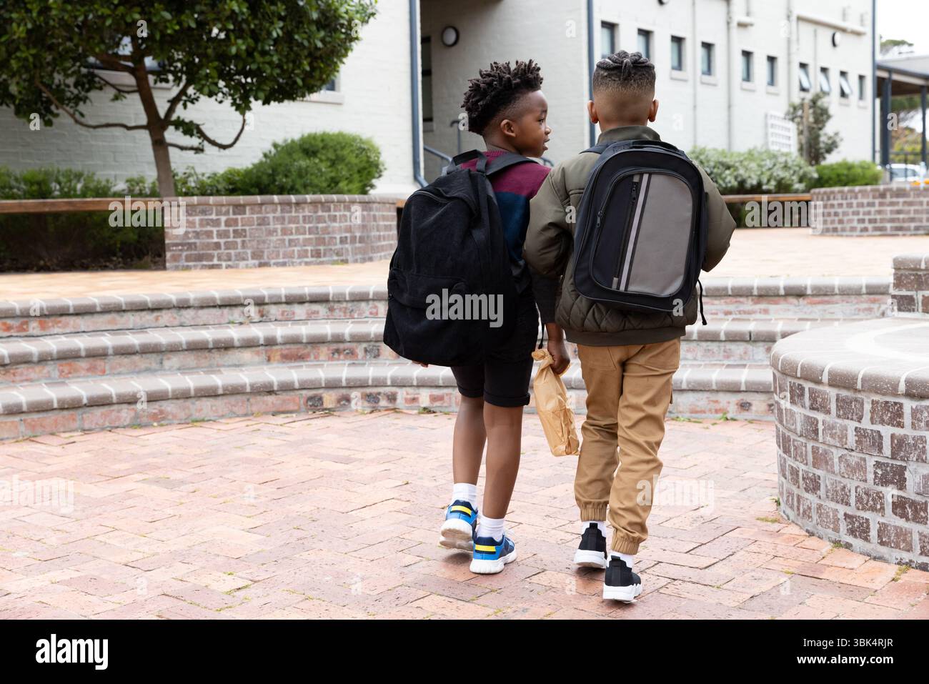 Two boys walking backpacks hi-res stock photography and images - Alamy