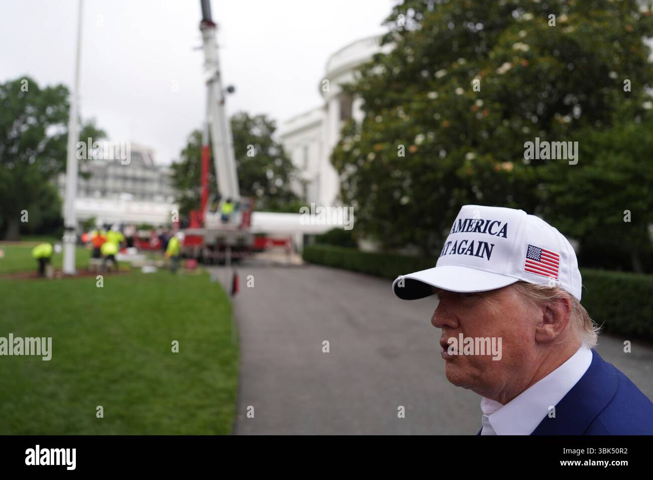 President Donald Trump speaks as a flag pole is installed on the South ...