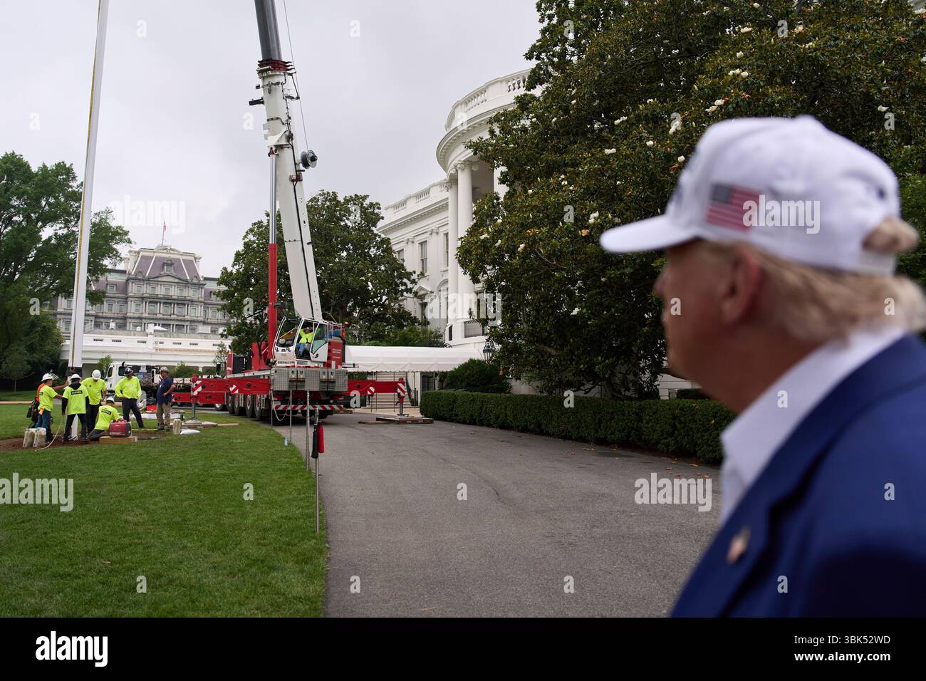 President Donald Trump watches as a flag pole is installed on the South ...
