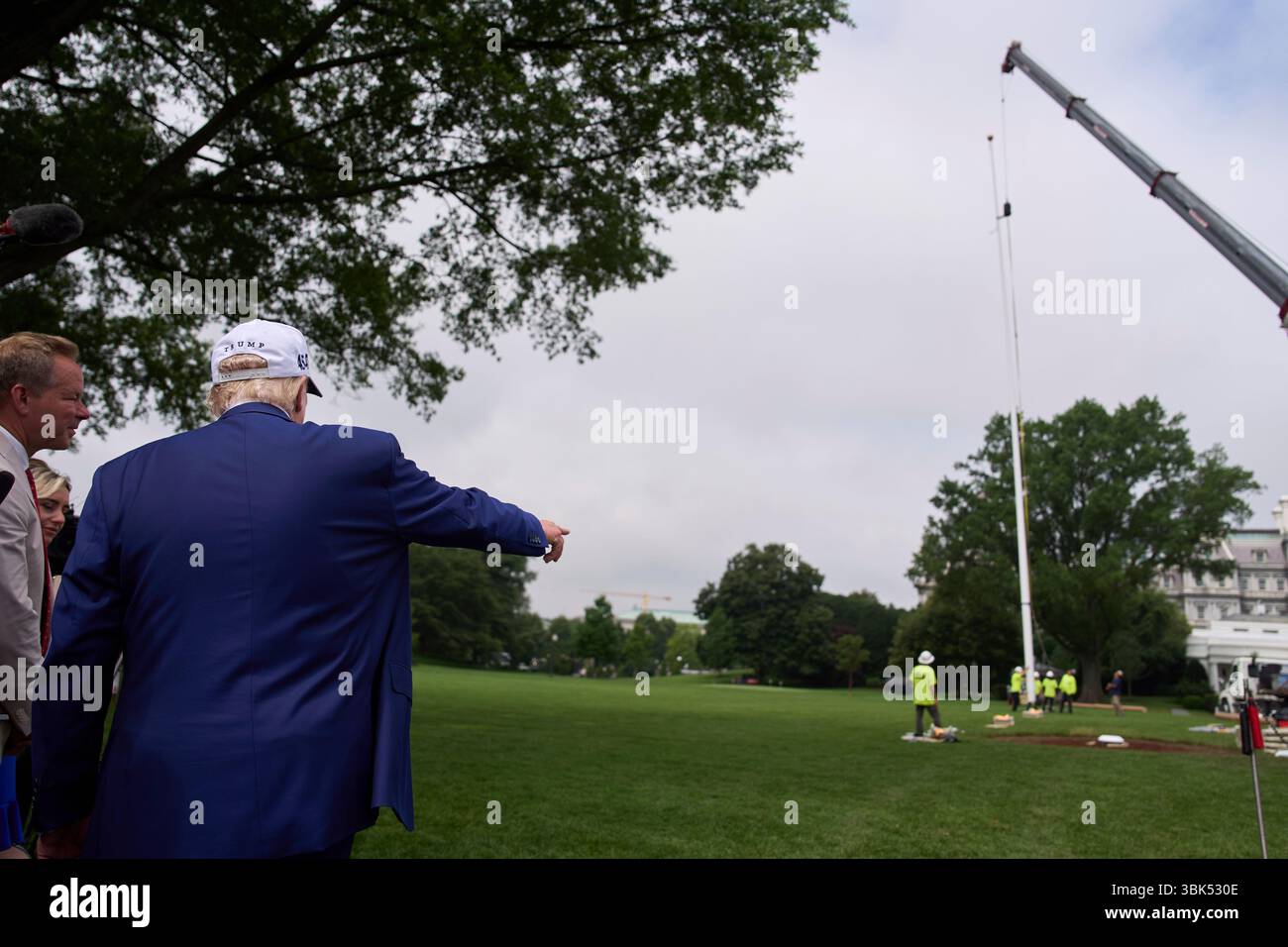 President Donald Trump speaks with reporters as a flag pole is ...