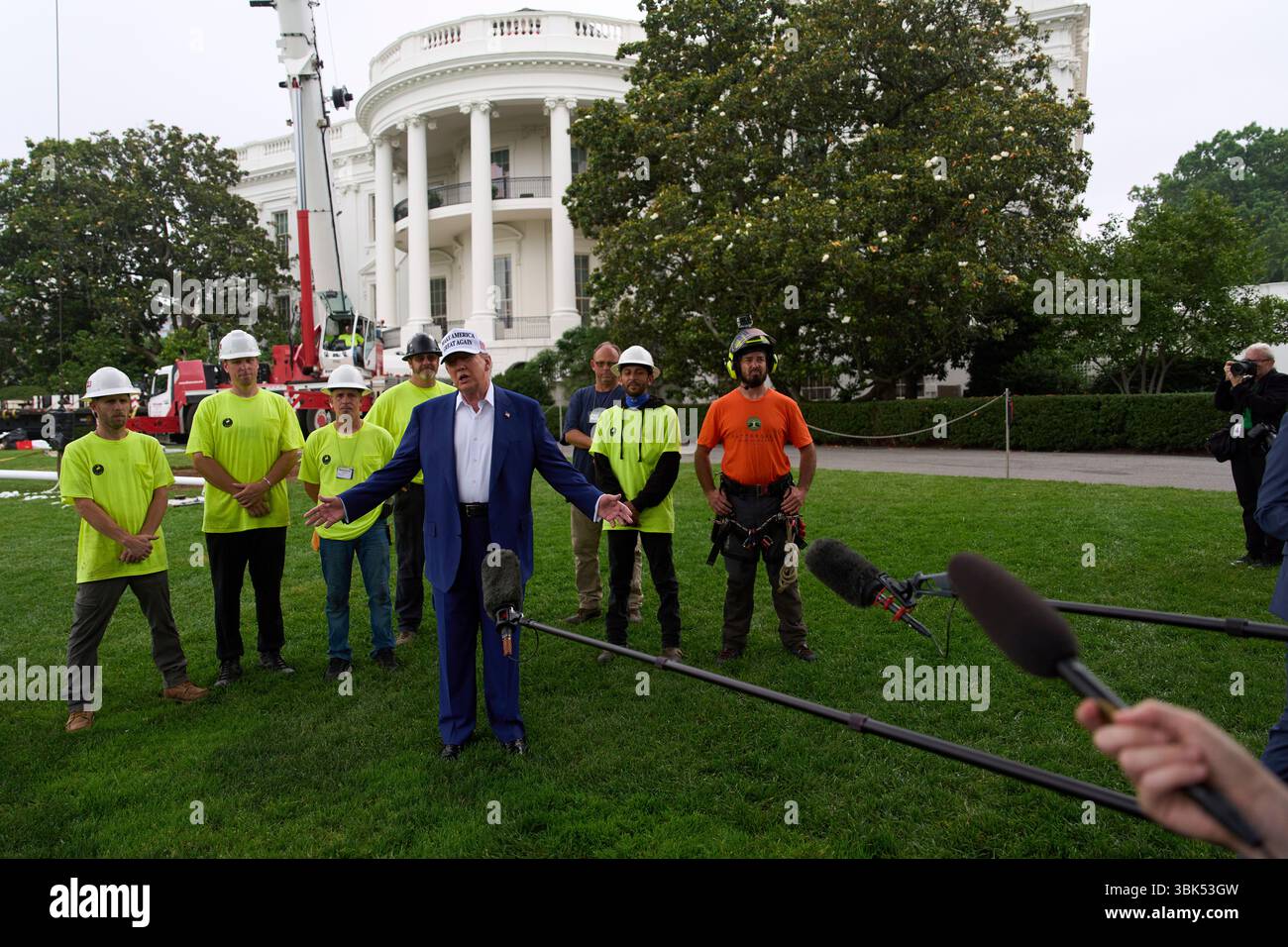President Donald Trump speaks with reporters as a flag pole is ...