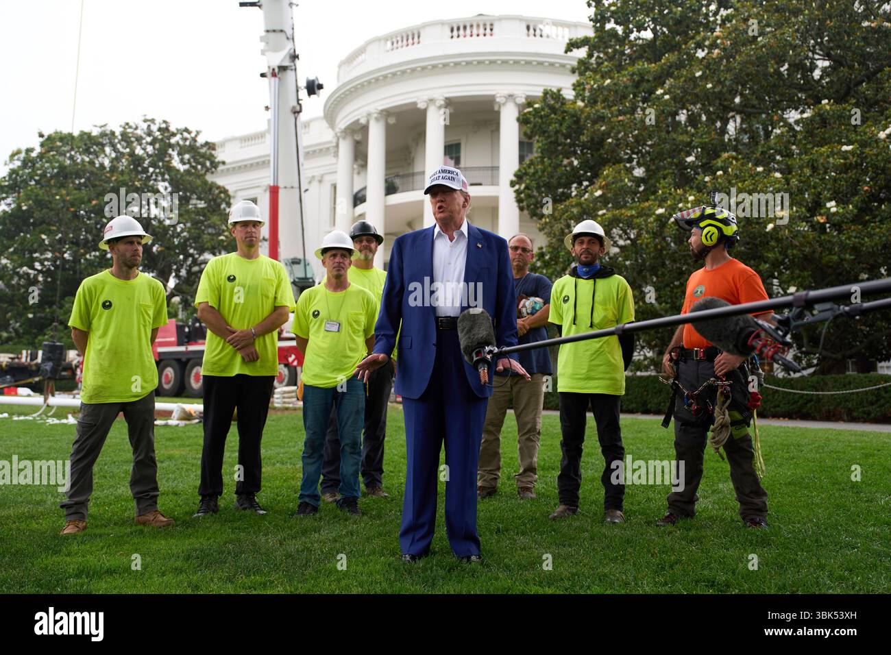 President Donald Trump speaks with reporters before a flag pole is ...