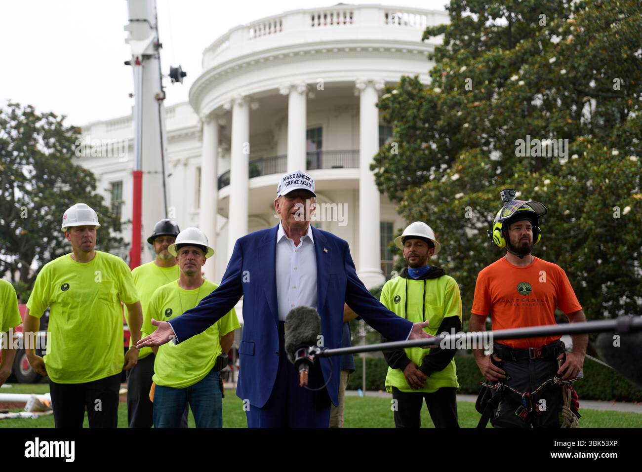 President Donald Trump speaks with reporters before a flag pole is ...