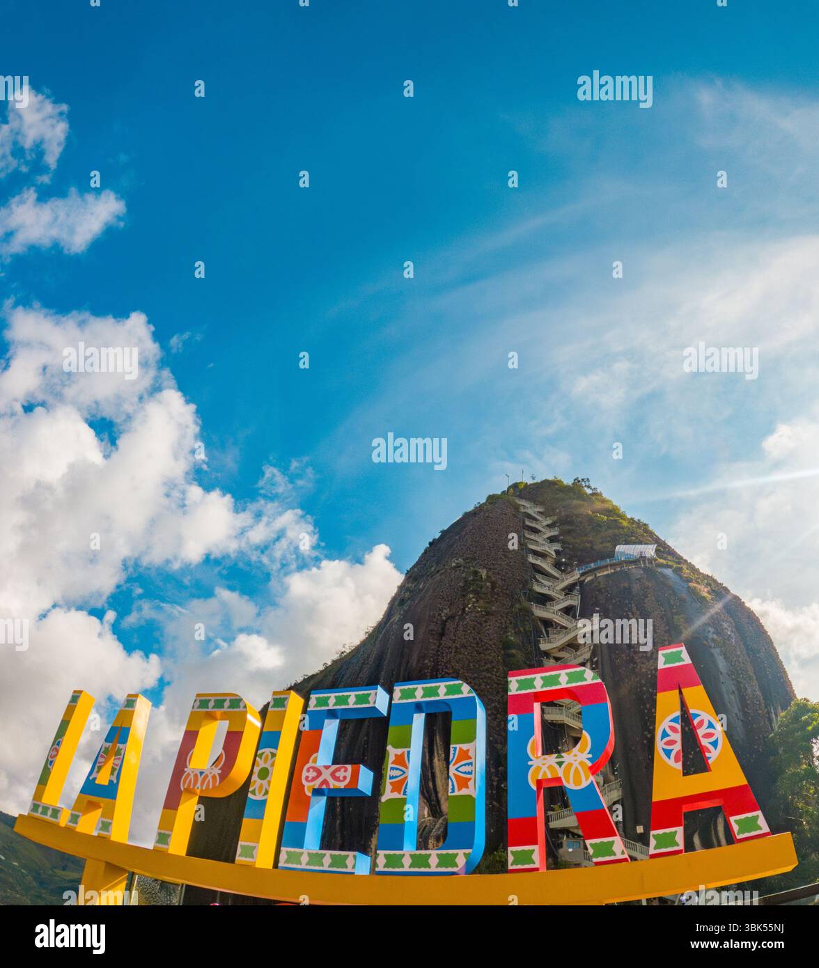 A colorful sign 'La Piedra' in front of the famous Peñol Stone in ...