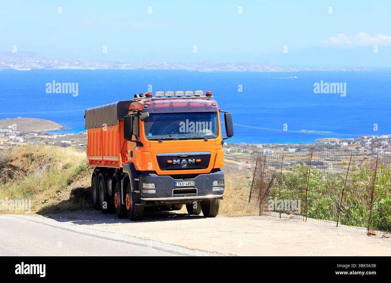Orange lorry parked on a steep hill, Tinos, The Cyclades island group ...