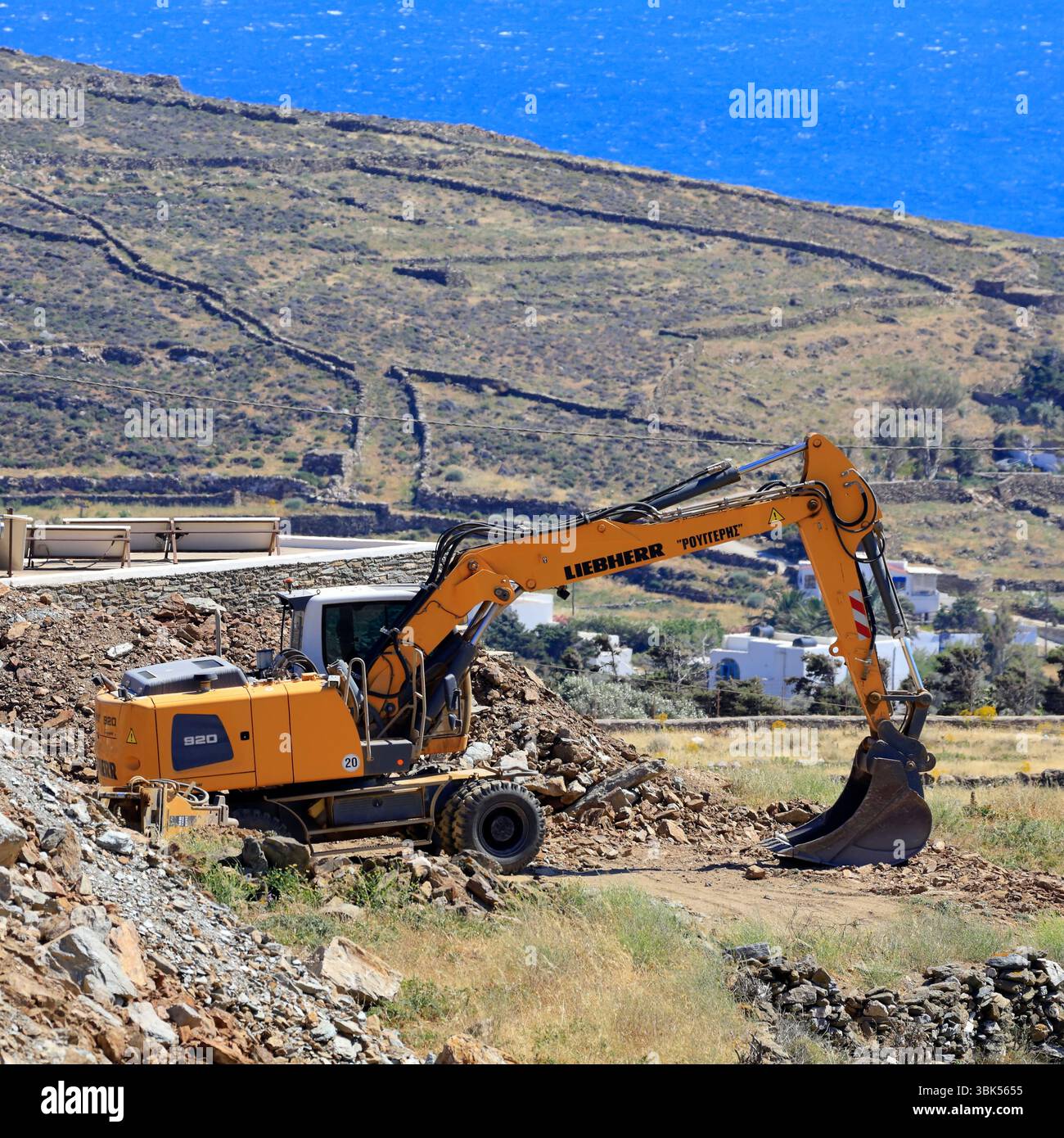 Large yellow Liebherr digger at work in the countryside, Tinos, The ...