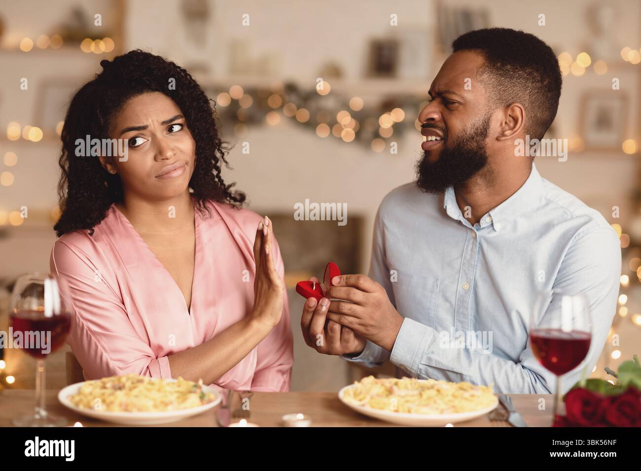 Black man making proposal with ring, woman rejecting Stock Photo - Alamy