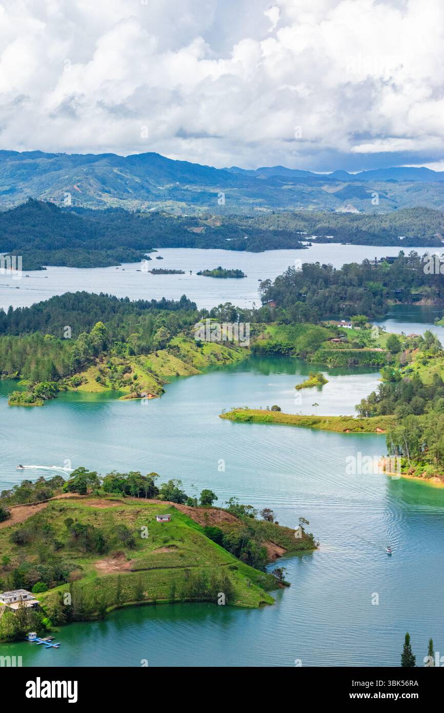 Stunning aerial view of Guatape Lake surrounded by lush greenery and hills, showcasing the ...