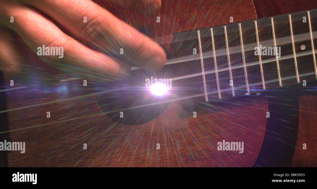 Strumming hand in dark sleeve pressing steel strings on acoustic guitar ...