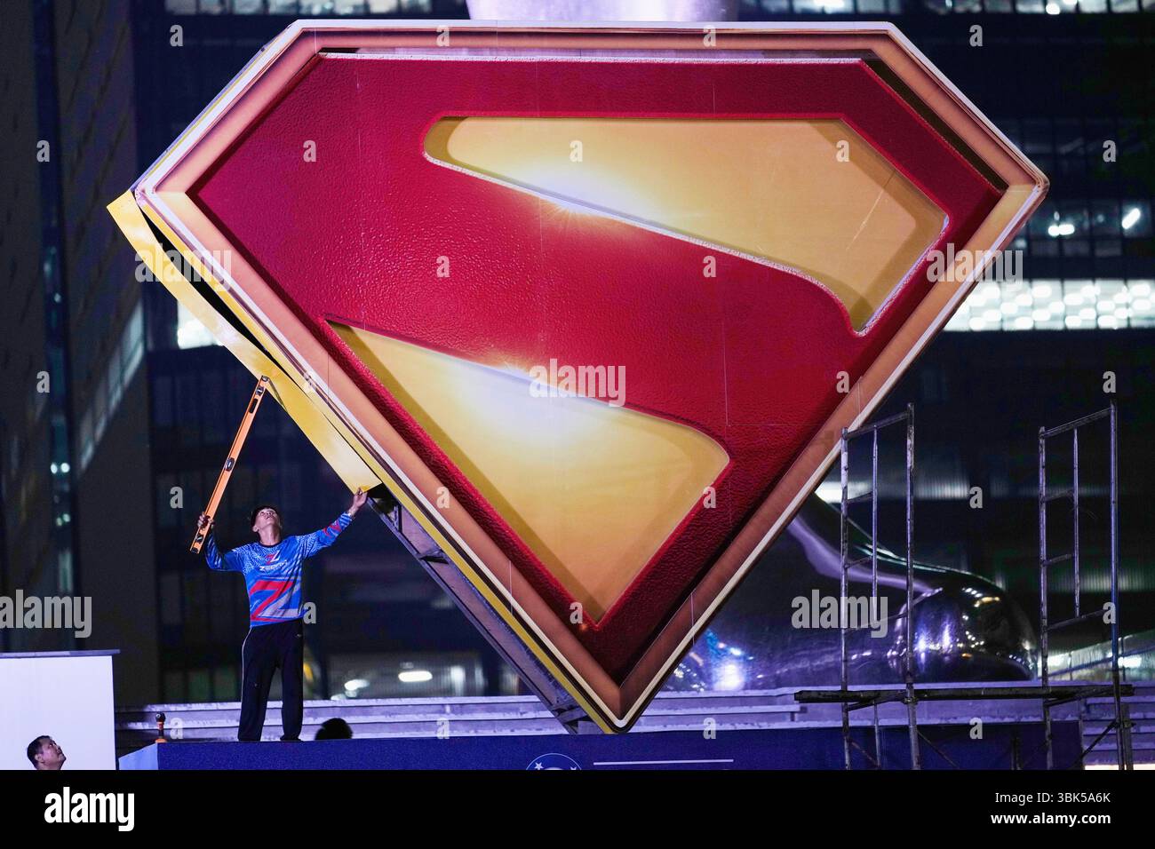 A worker fixes the "Superman" sign during an event in Pasig city ...