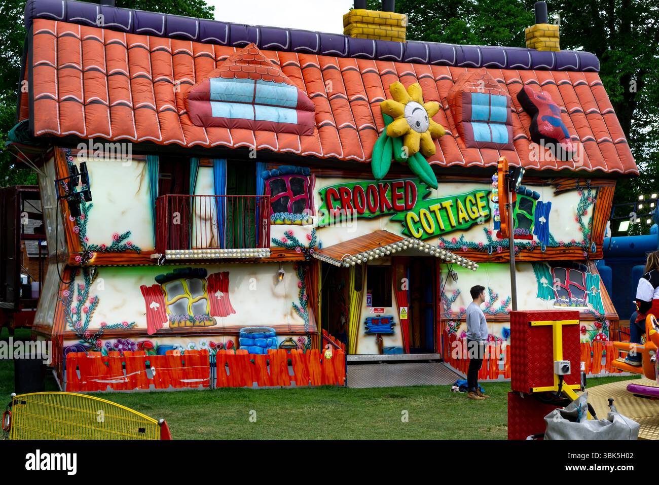 The Crooked Cottage funfair ride at a vibrant festival in Saffron ...