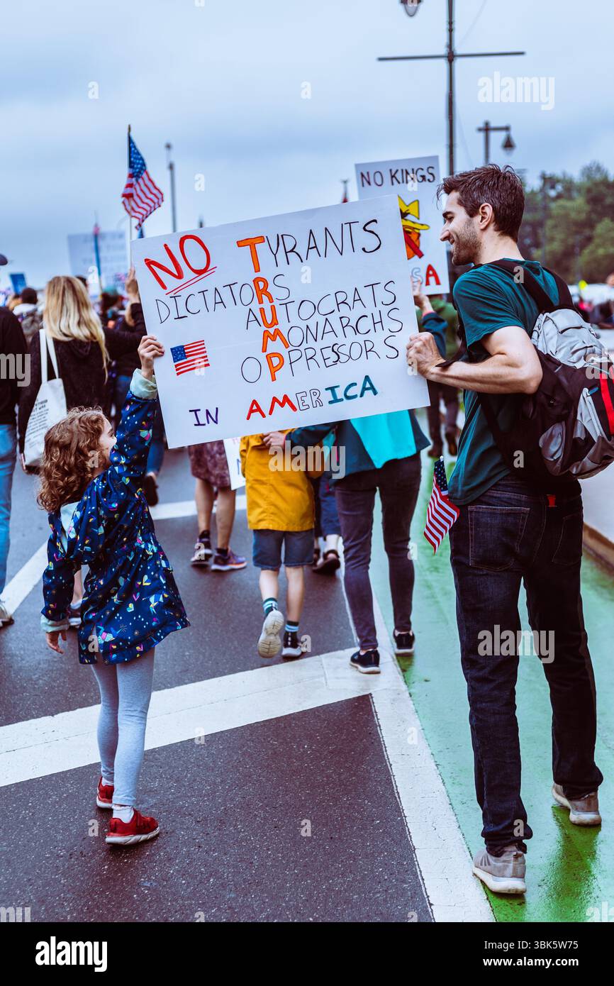 Father and daughter hold an anti-Trump protest sign at the No Kings ...
