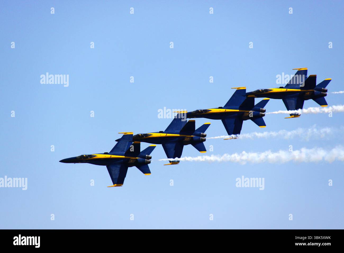 Four U.S. Navy Blue Angels jets fly in tight formation against a clear ...